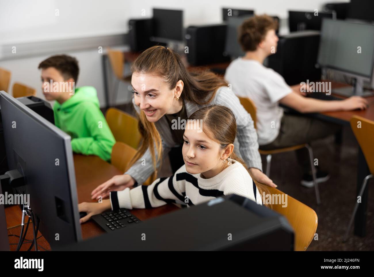 Female teacher and teenage girl looking at monitor of PC Stock Photo ...