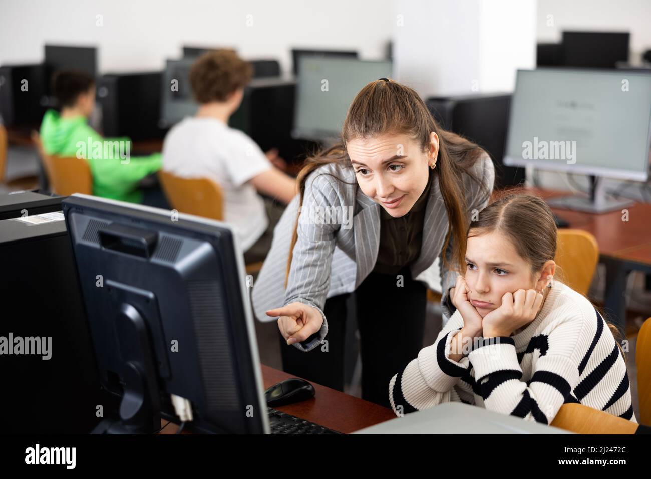 Positive woman teacher together with the girl teaches how to work on ...