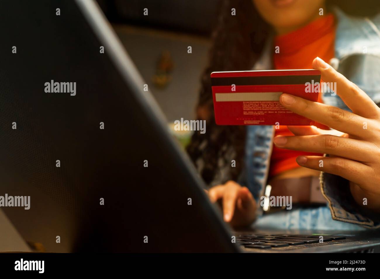 Unrecognizable latin teenager holding his credit card in his hand and ...