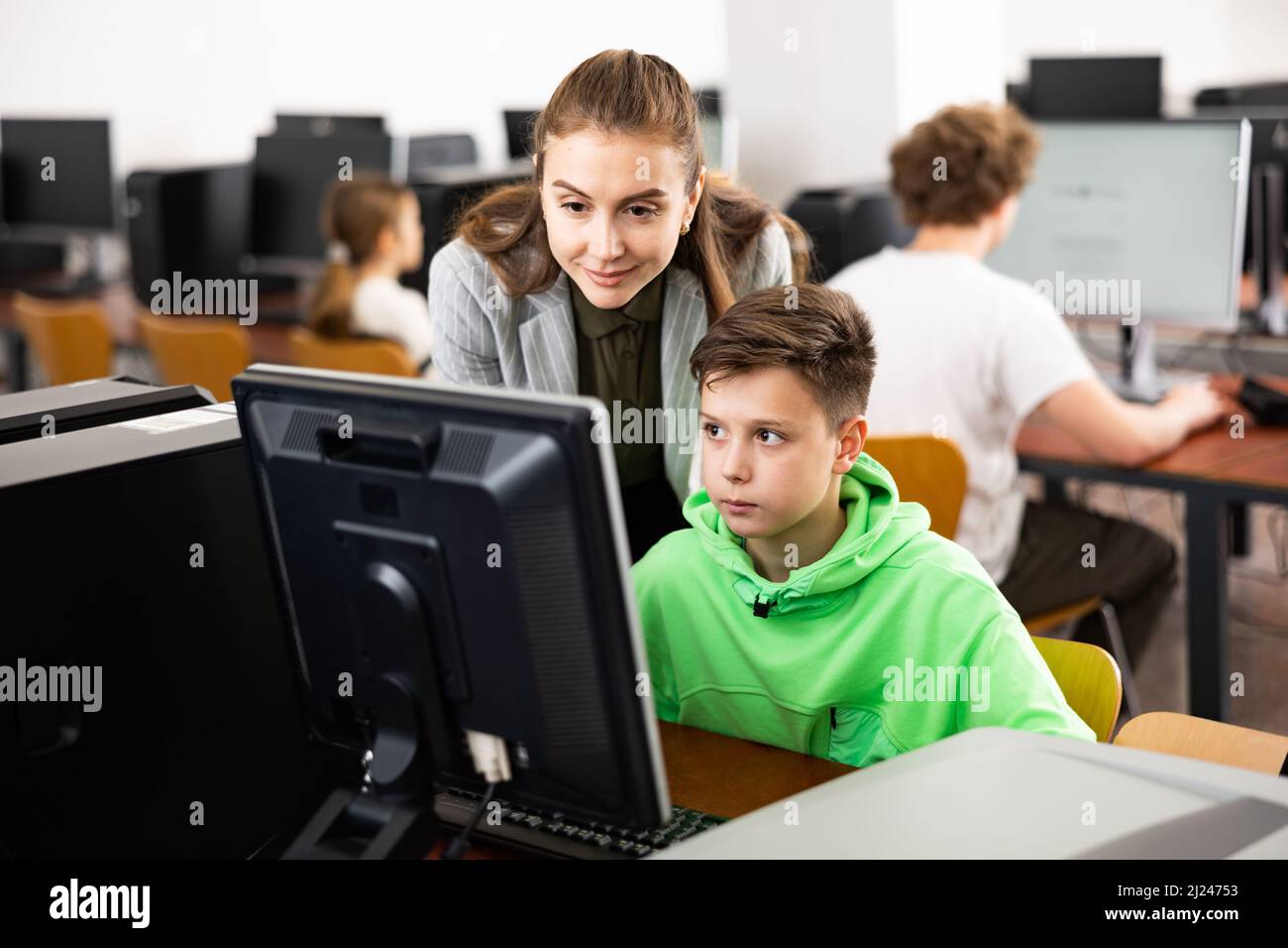 Teacher together with students conduct lesson on computer education ...