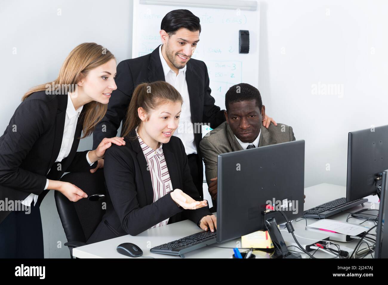 Business team working together, looking at computer screen Stock Photo ...