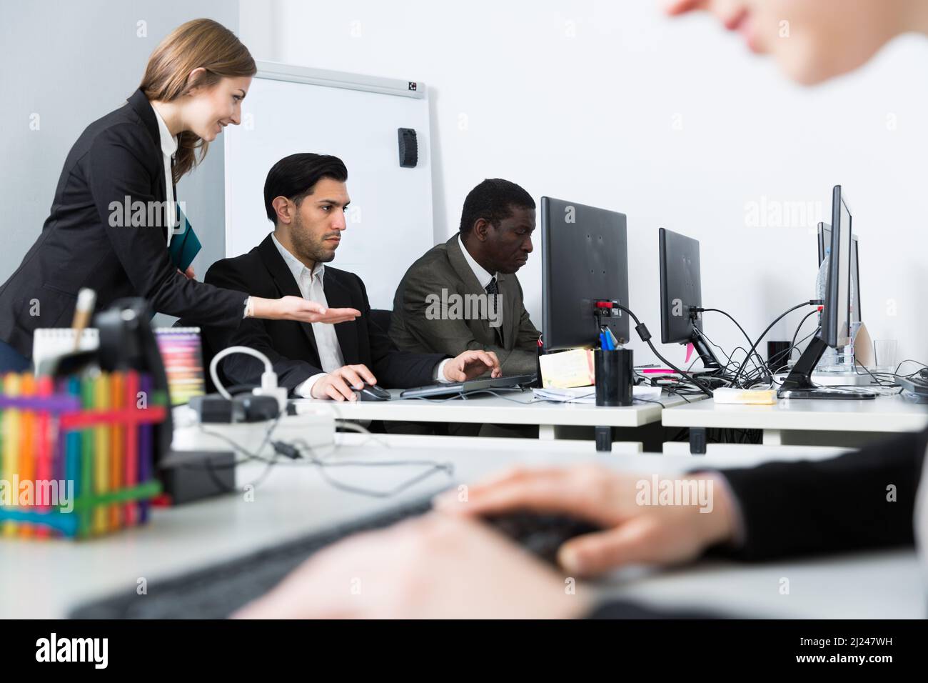 Nice girl helping male colleague in work Stock Photo - Alamy