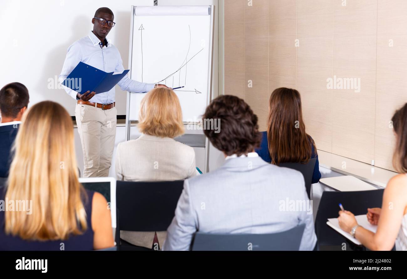 African man presenting business project to coworkers Stock Photo - Alamy