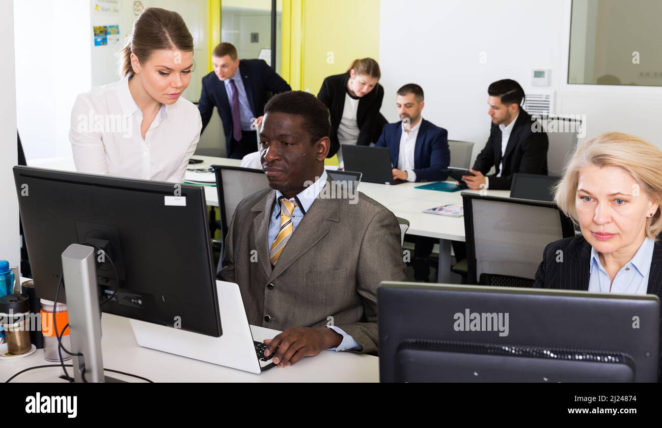Coworkers engaged in open plan office Stock Photo - Alamy