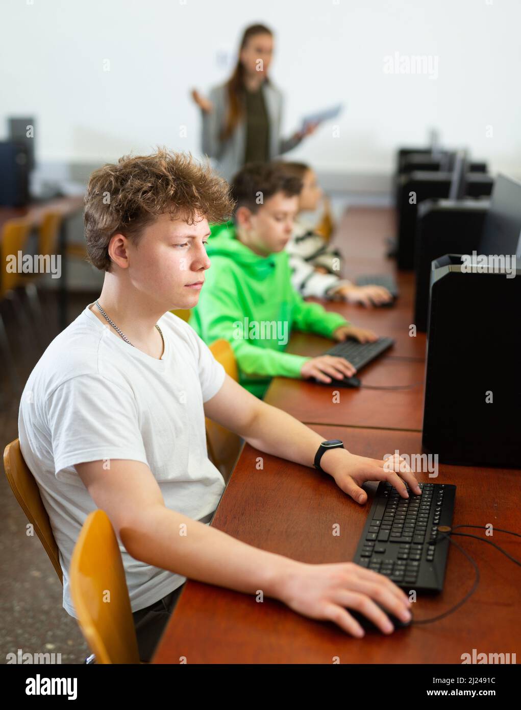 Teenage student learning basics of programming in computer college ...