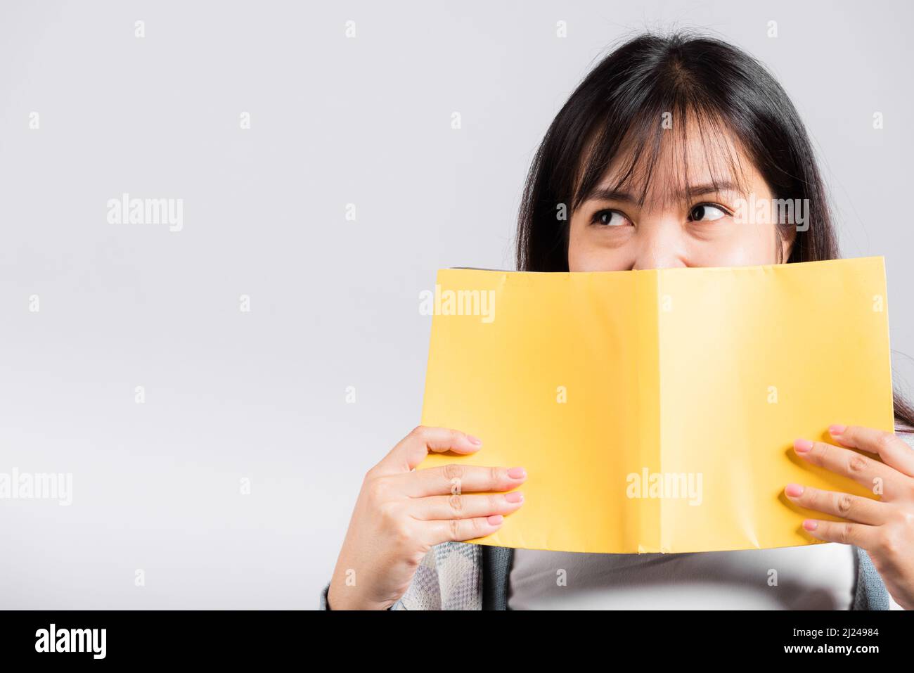 Woman teen smiling covering her face with open book, Portrait of ...