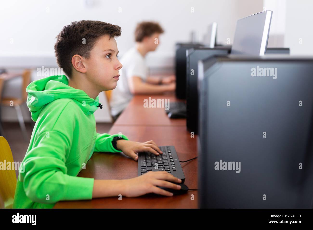 Portrait of students at computers in computer class Stock Photo - Alamy