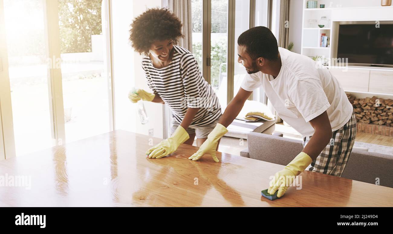 We make a great team. Shot of a cheerful young couple cleaning the ...