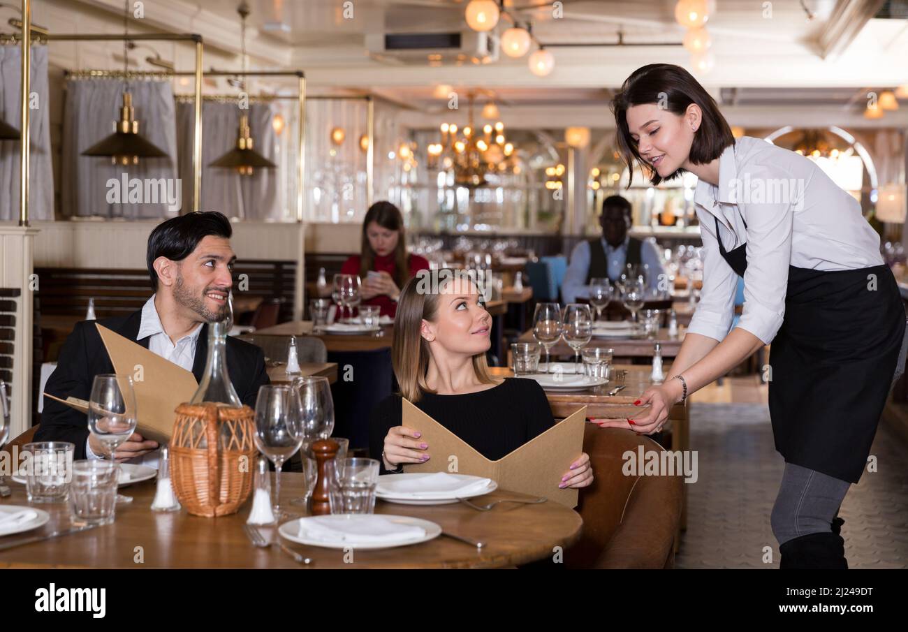 Waitress talking with restaurant guests Stock Photo - Alamy