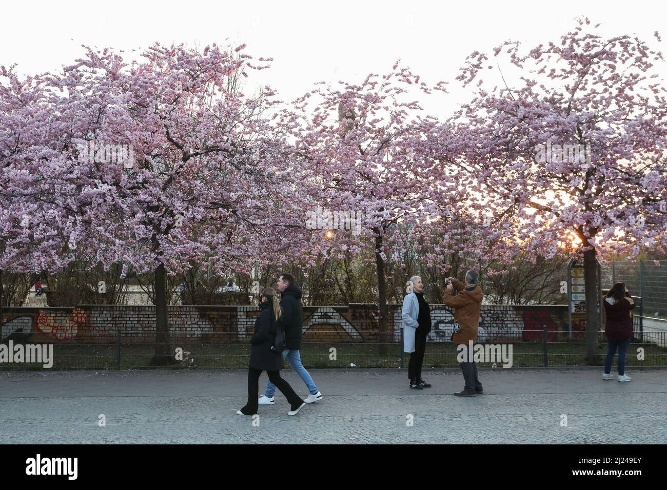 Berlin, Germany. 29th Mar, 2022. People walk on the street flanked by ...