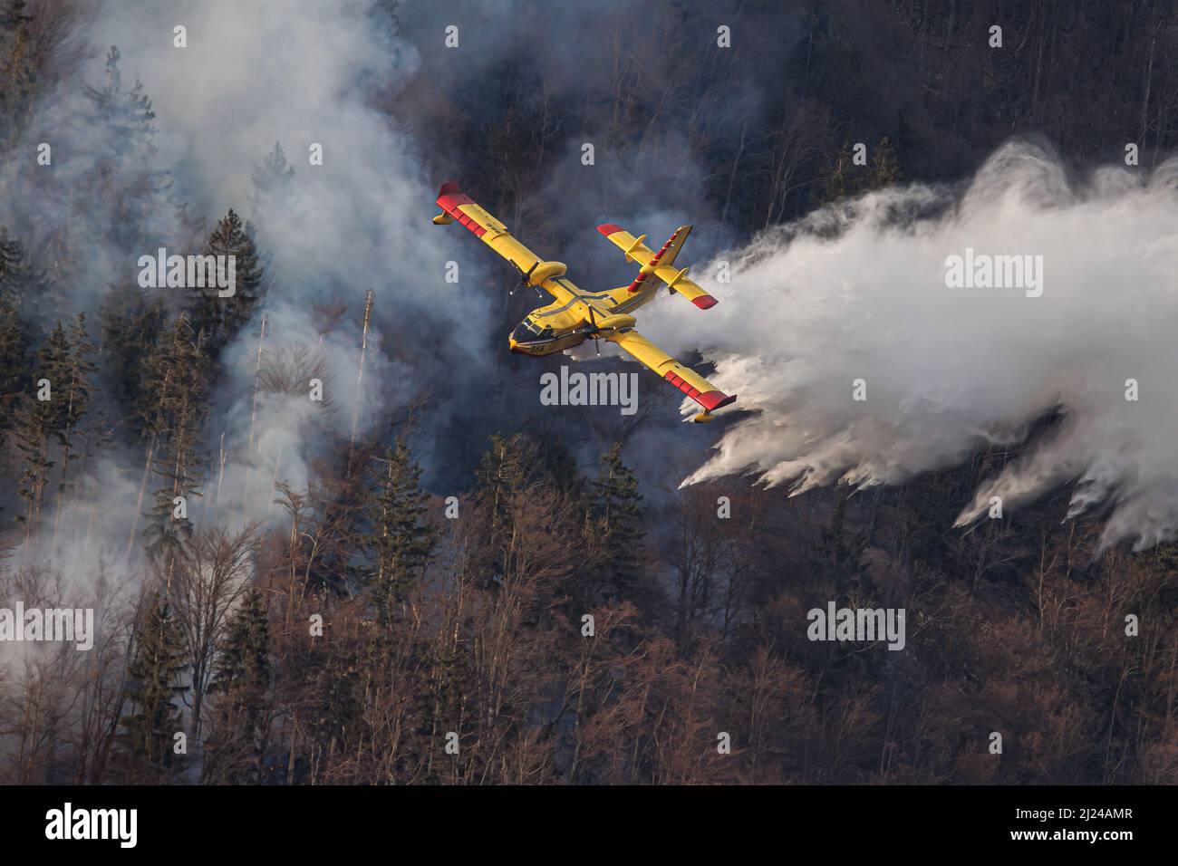 A Croatian Canadair CL-415 firefighting plane drops water on a wildfire ...