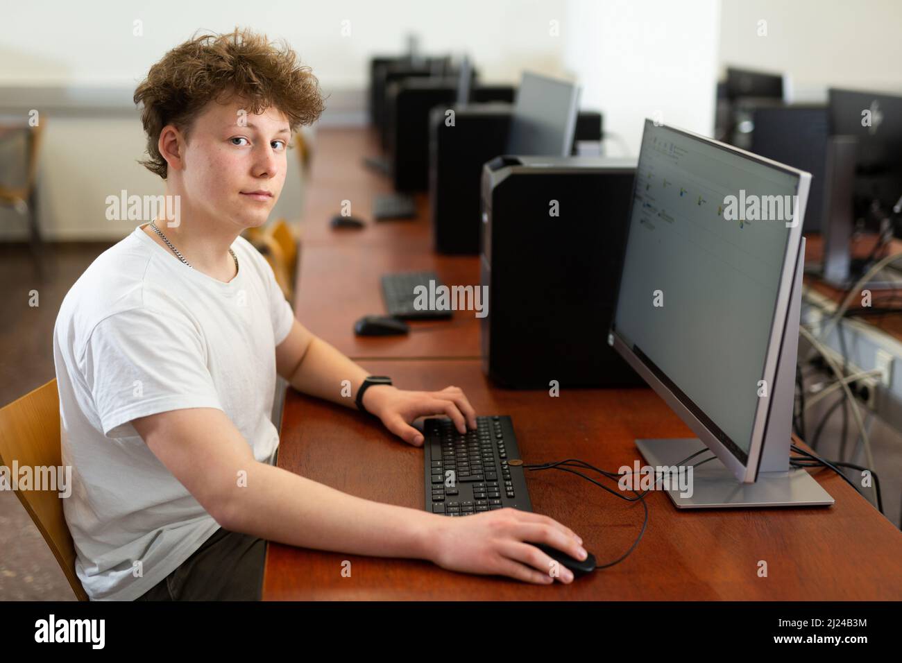 Portrait of guy working at computer in computer class at school Stock ...