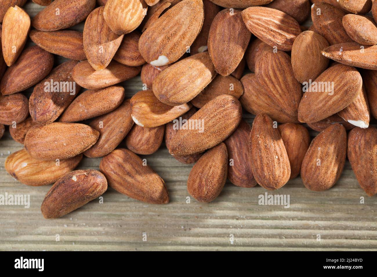 Roasted almonds on light wood surface Stock Photo - Alamy