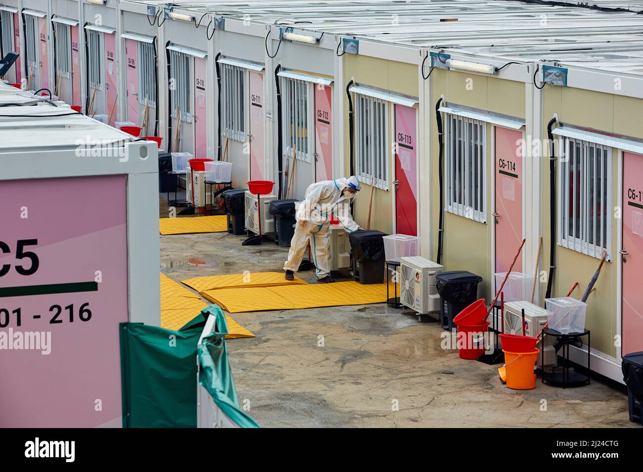 A worker wearing personal protective equipment (PPE) cleans at a Covid ...