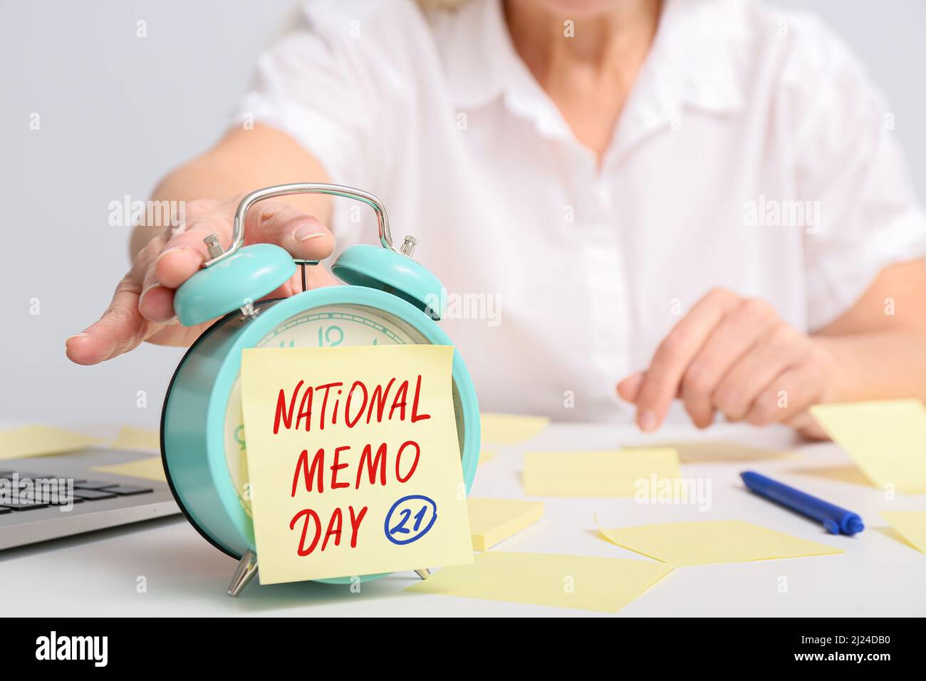 Alarm clock and sticky note paper with text NATIONAL MEMO DAY on table ...