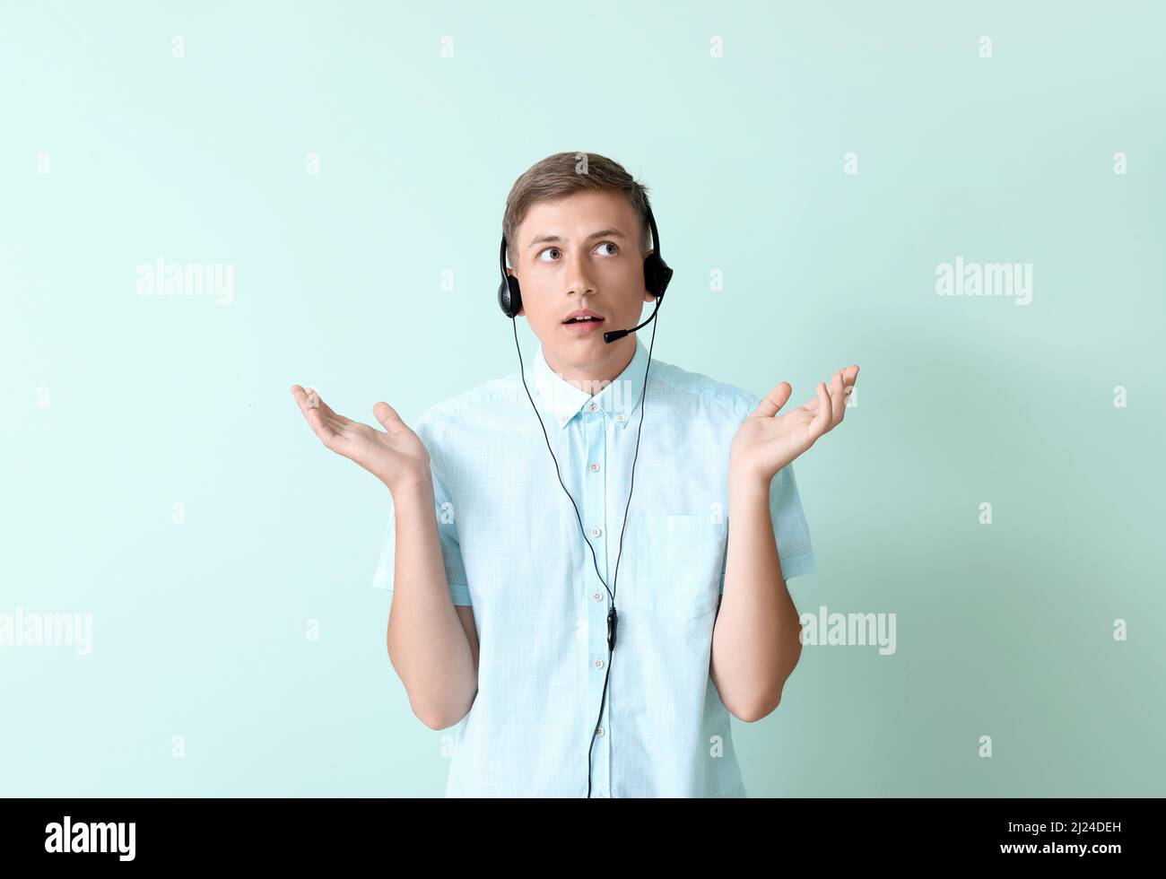 Confused consultant of call center in headset on blue background Stock ...