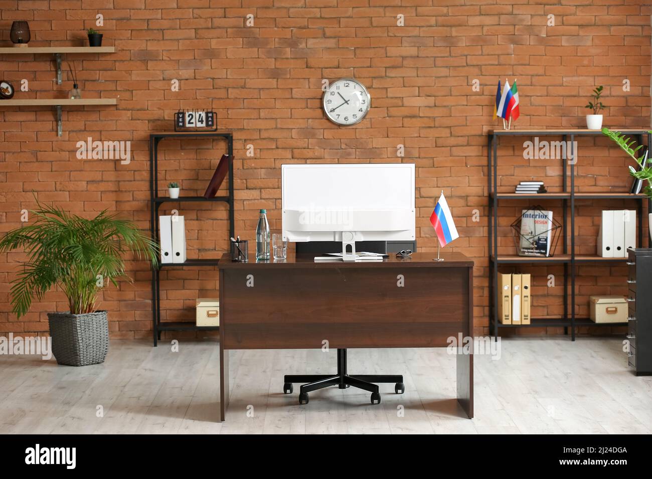 Interior of modern office with computer and Russian flag on dark wooden ...
