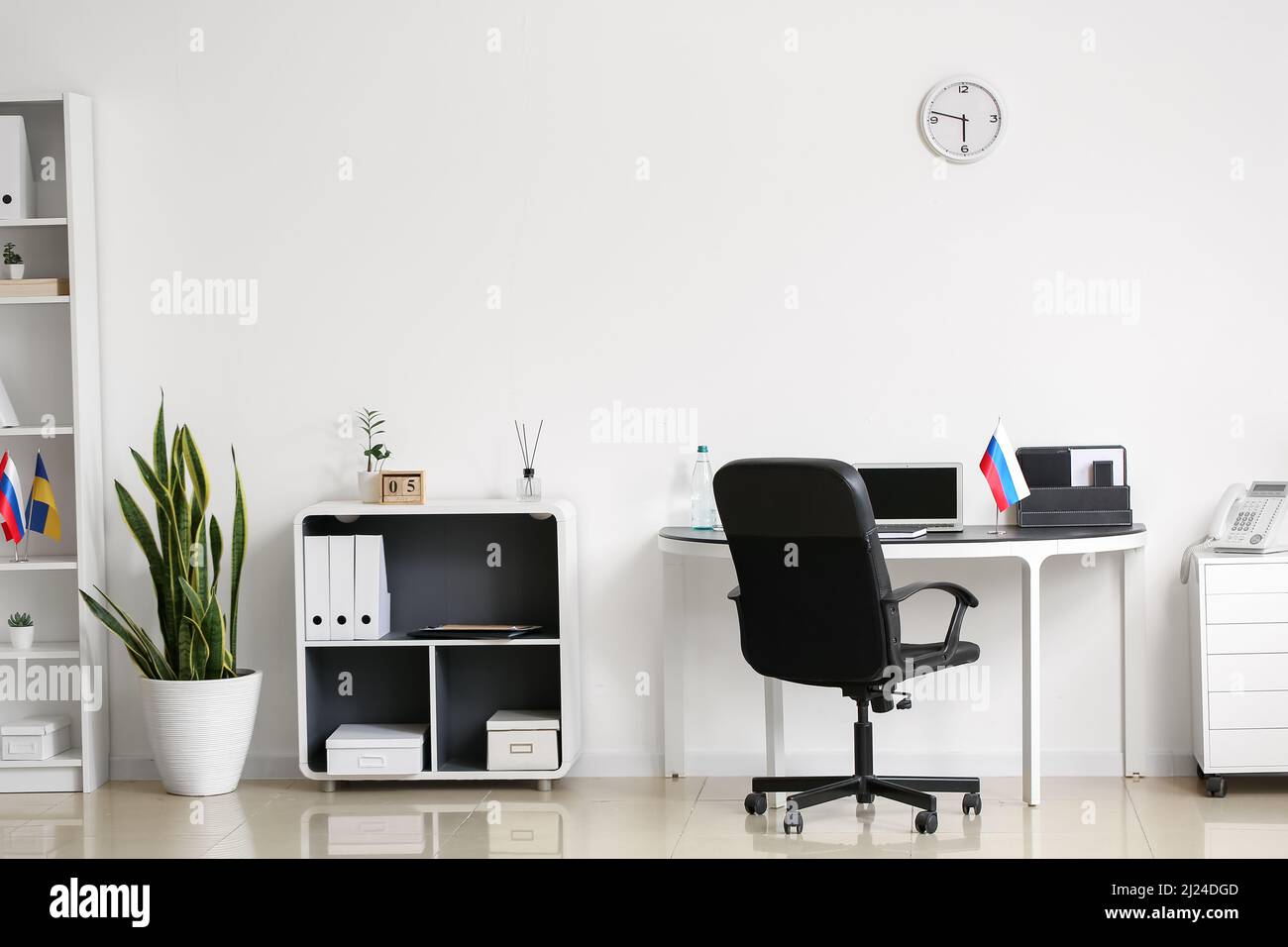 Interior of modern office with Russian flag on table near light wall ...