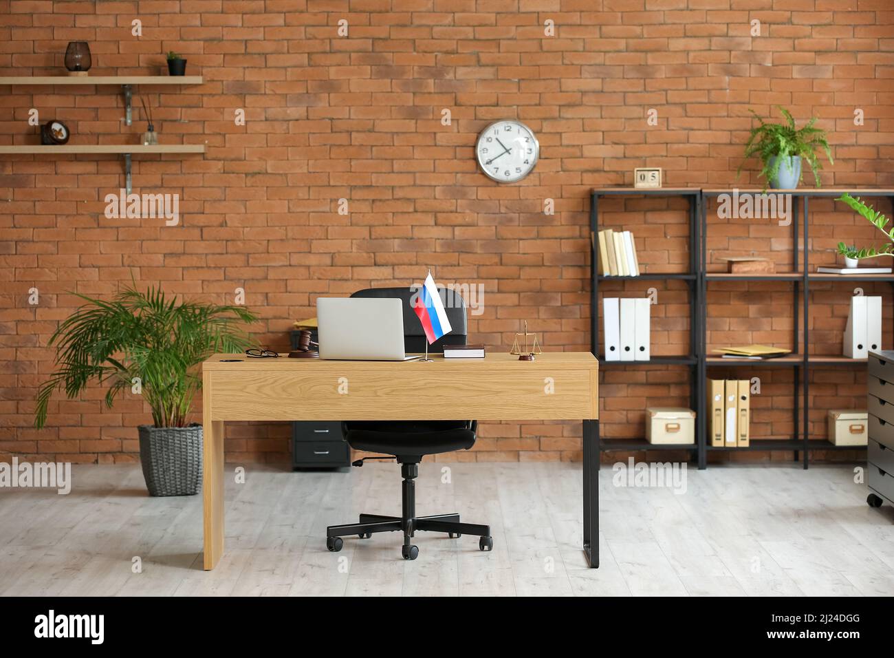Interior of judge office with modern laptop and Russian flag on table ...