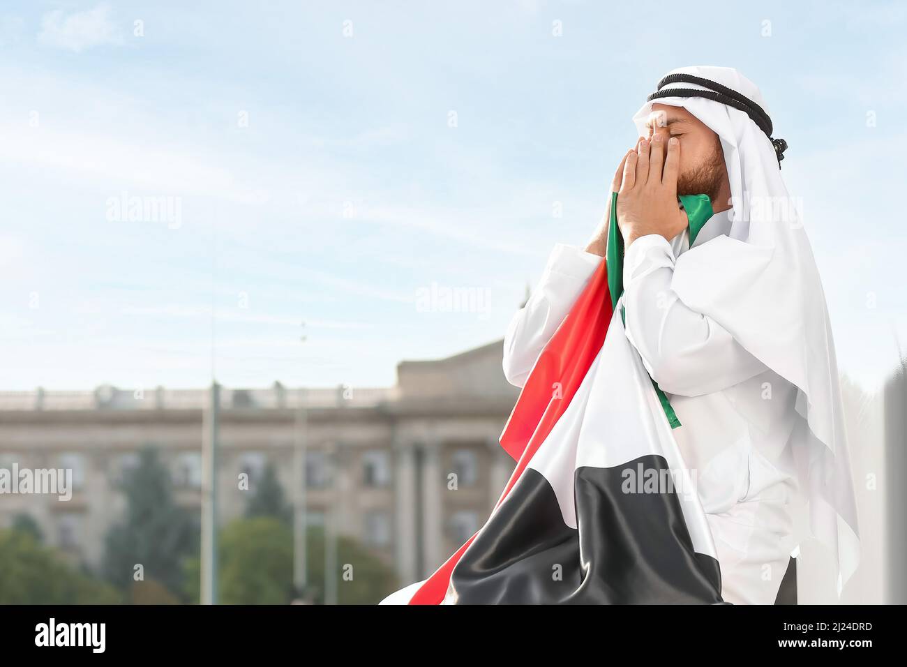 Handsome Muslim man with UAE flag sitting on bench outdoors Stock Photo ...