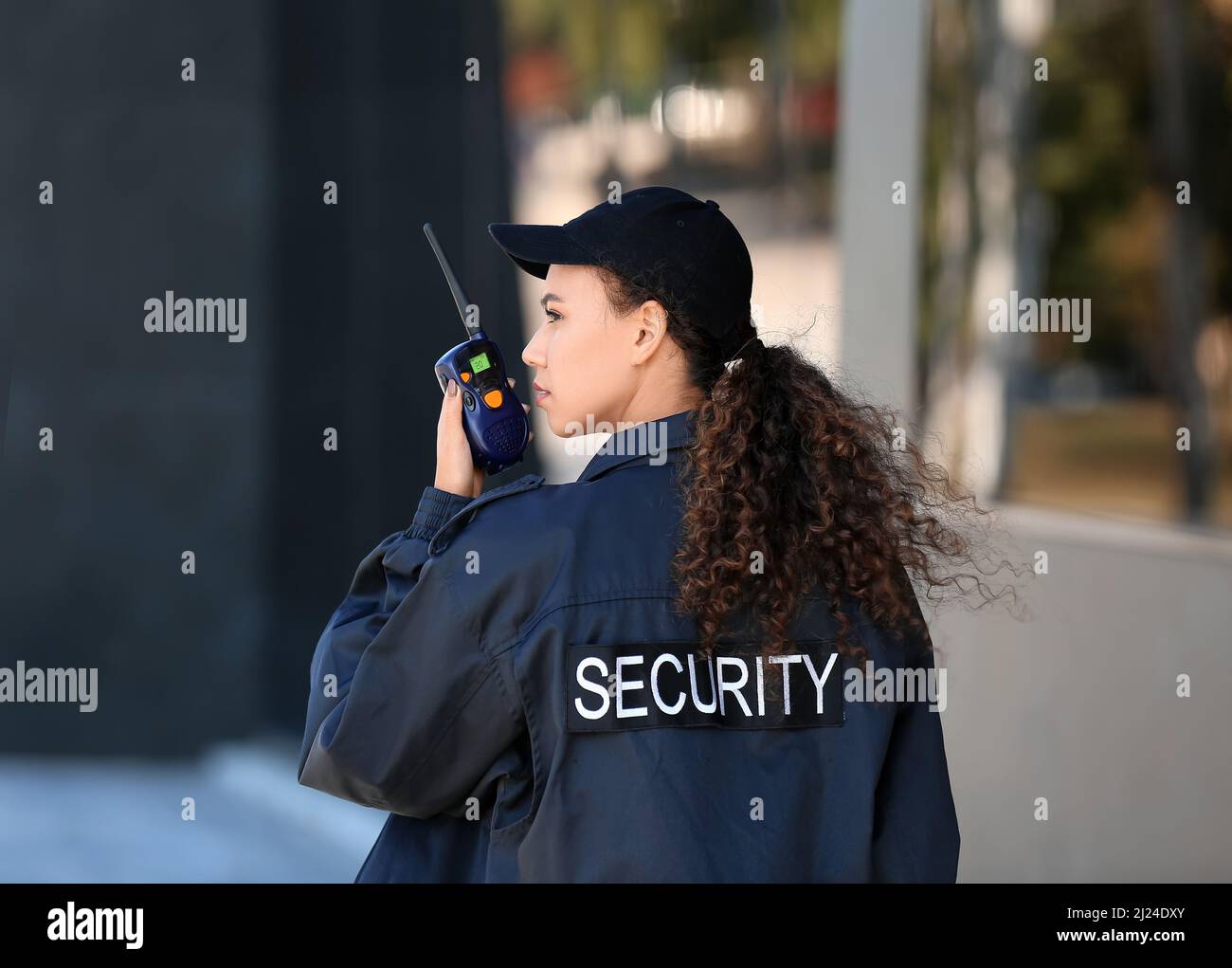 African-American female security guard with radio transmitter near ...