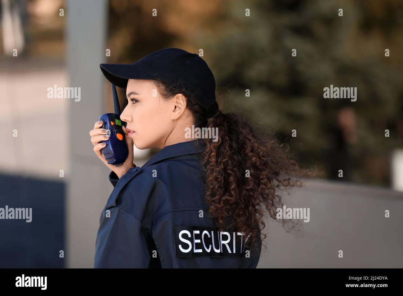 African-American female security guard with radio transmitter near ...