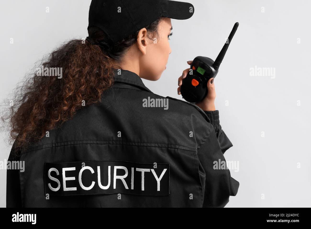 African-American female security guard with radio transmitter on light ...