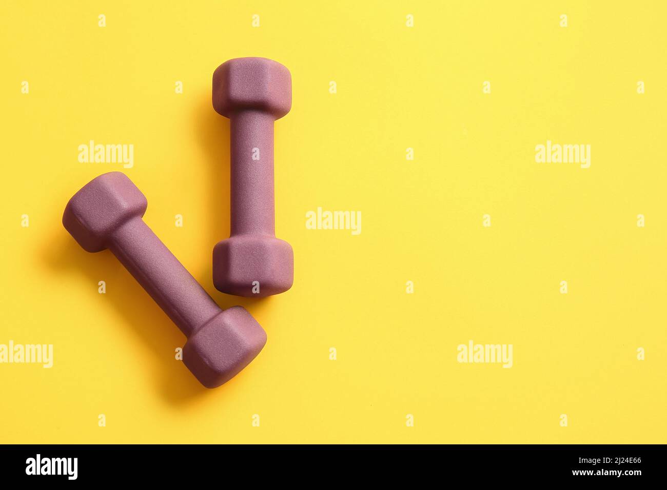 Stylish dumbbells on yellow background Stock Photo - Alamy