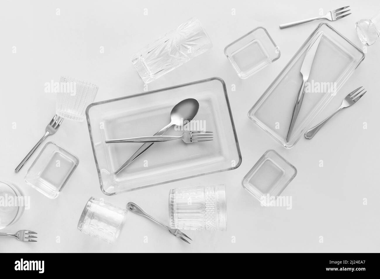 Set of beautiful glass dinnerware on light background Stock Photo - Alamy