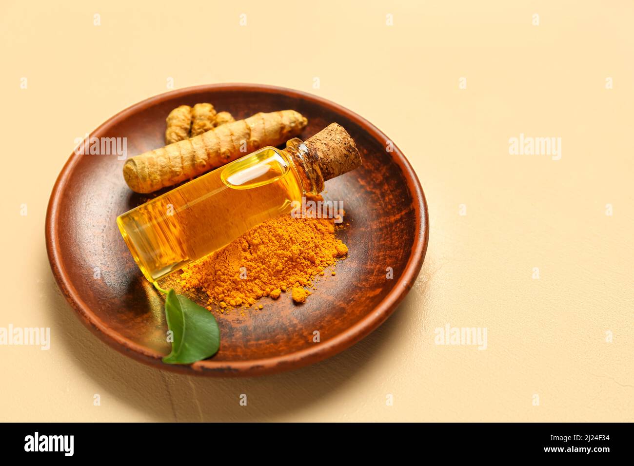 Bottle of oil, turmeric root and powder on beige background Stock Photo ...