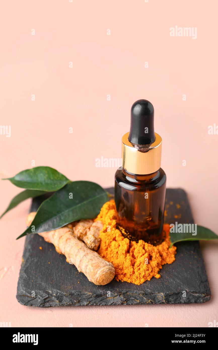 Bottle of oil, turmeric root and powder on beige background Stock Photo ...