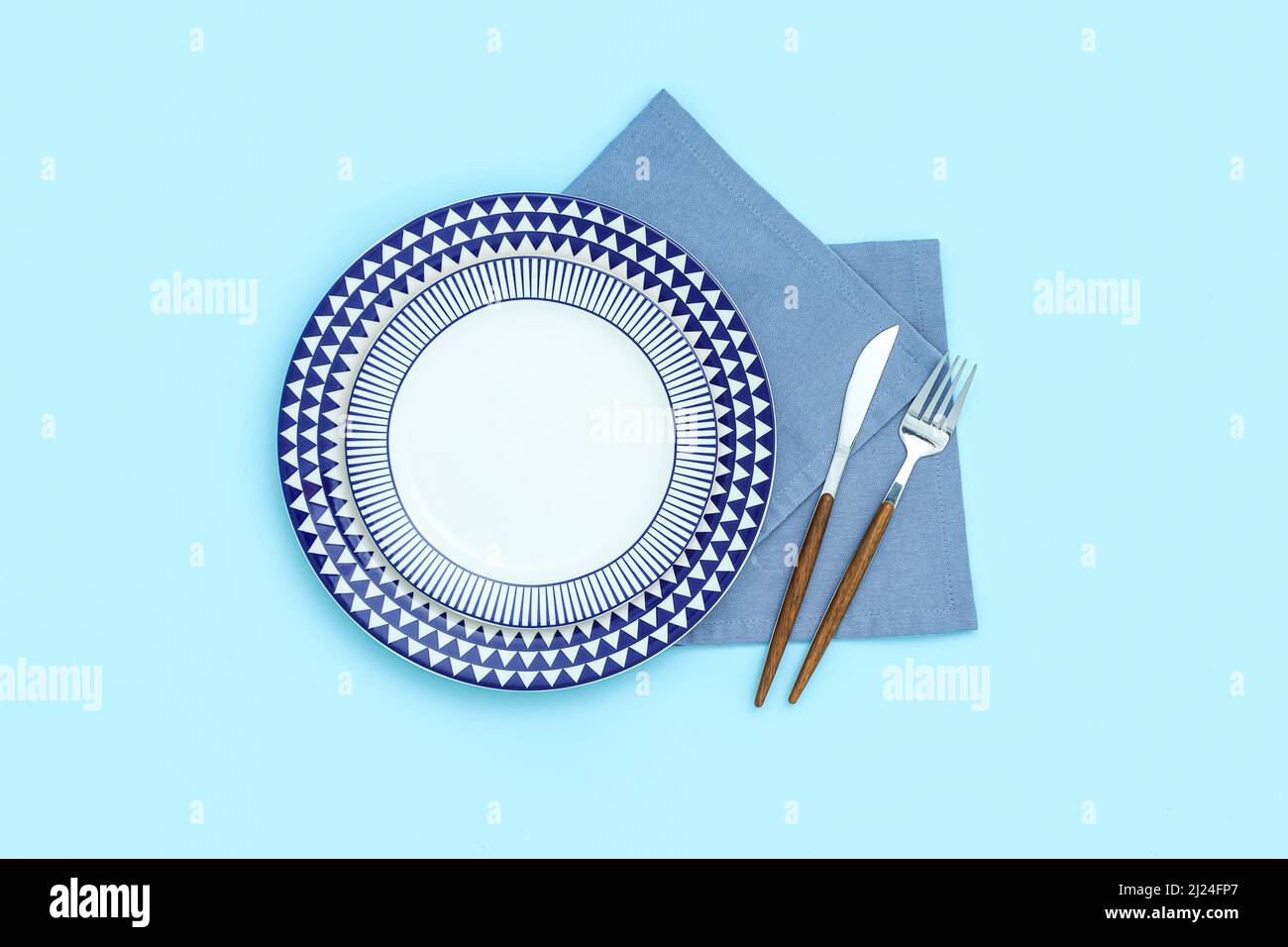 Simple table setting on blue background Stock Photo - Alamy