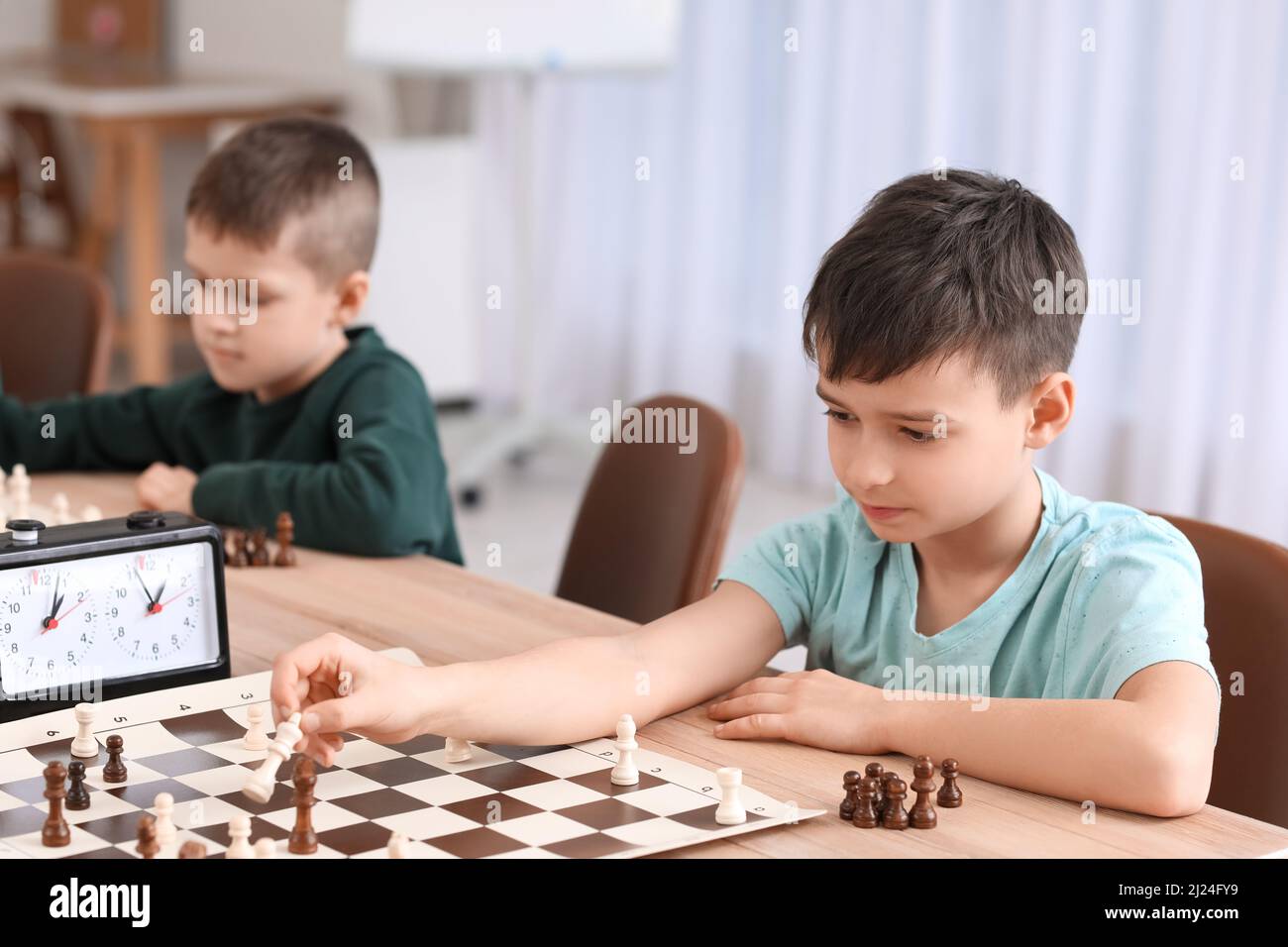 Little children playing chess during tournament in club Stock Photo - Alamy