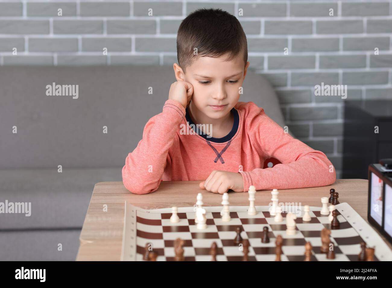 Little boy playing chess during tournament in club Stock Photo - Alamy