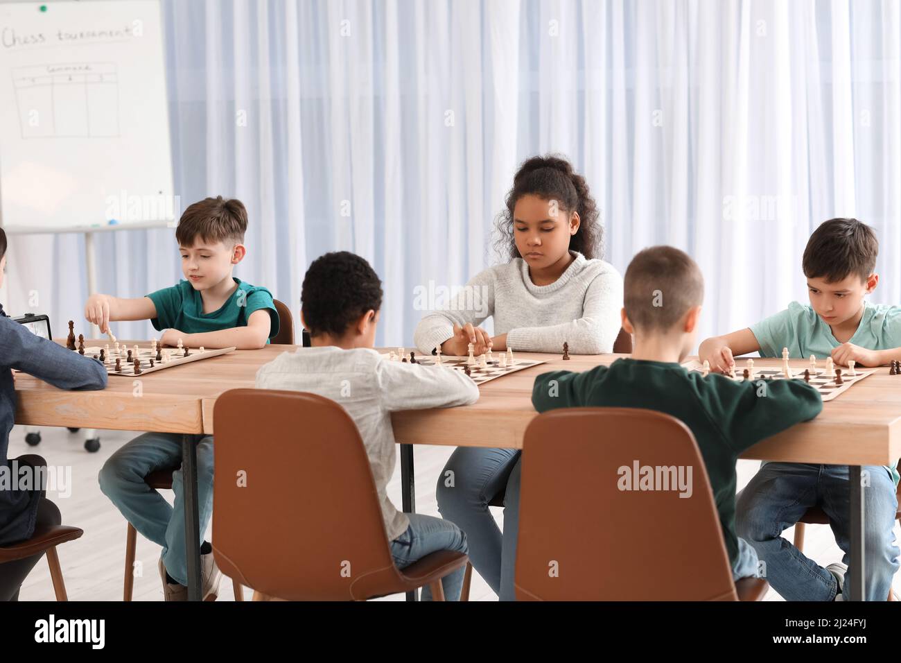 Little children playing chess during tournament in club Stock Photo - Alamy