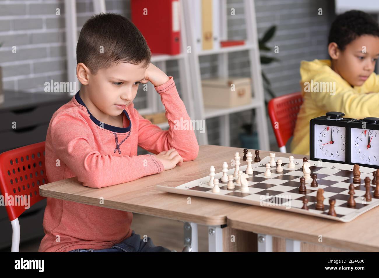Little children playing chess during tournament in club Stock Photo - Alamy