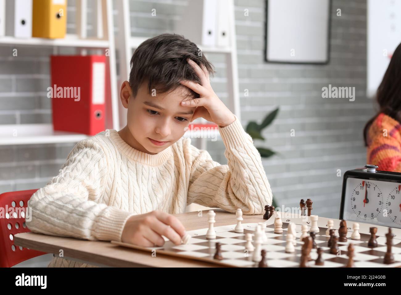 Little boy playing chess during tournament in club Stock Photo - Alamy