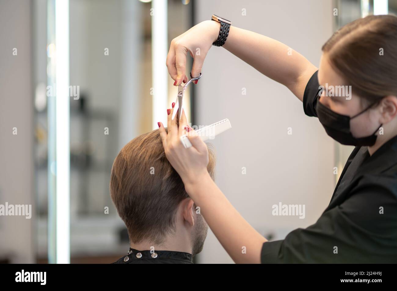 Close up picture of females hands with scissors cutting hair Stock Photo - Alamy