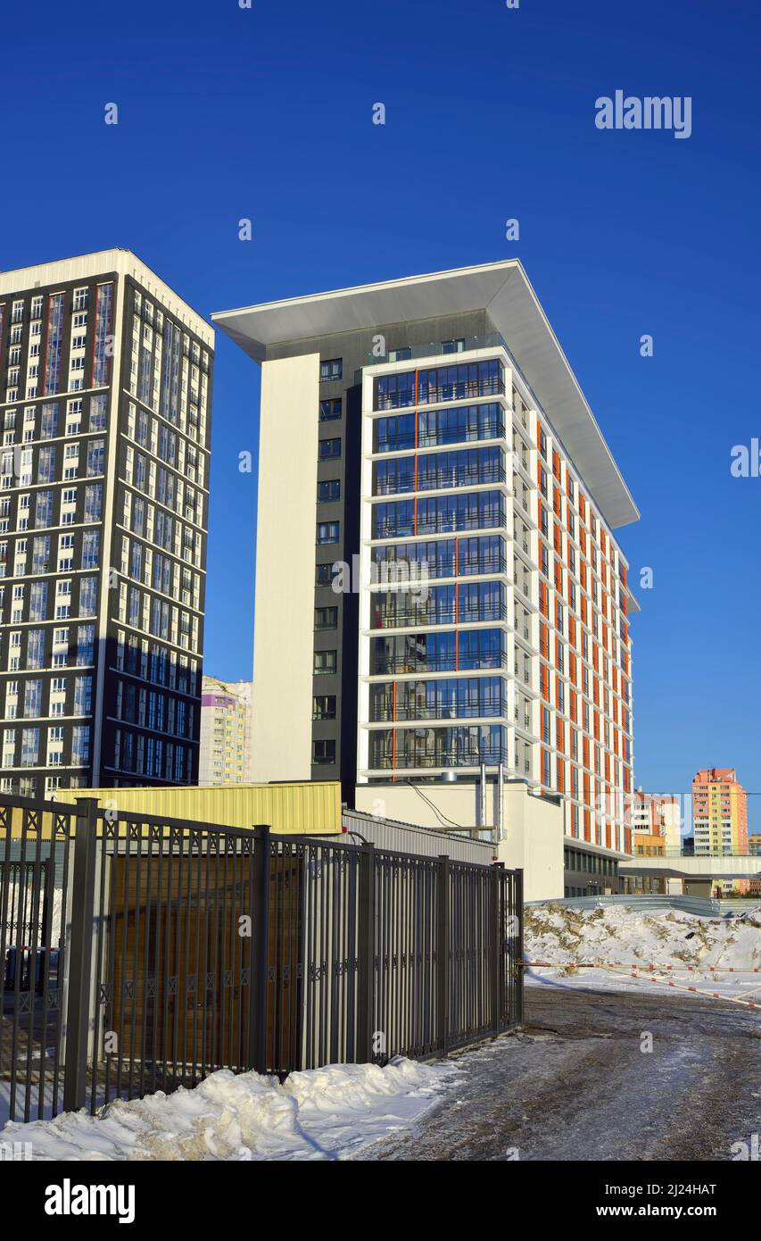 Houses on the winter embankment. Modern new buildings under a blue sky ...