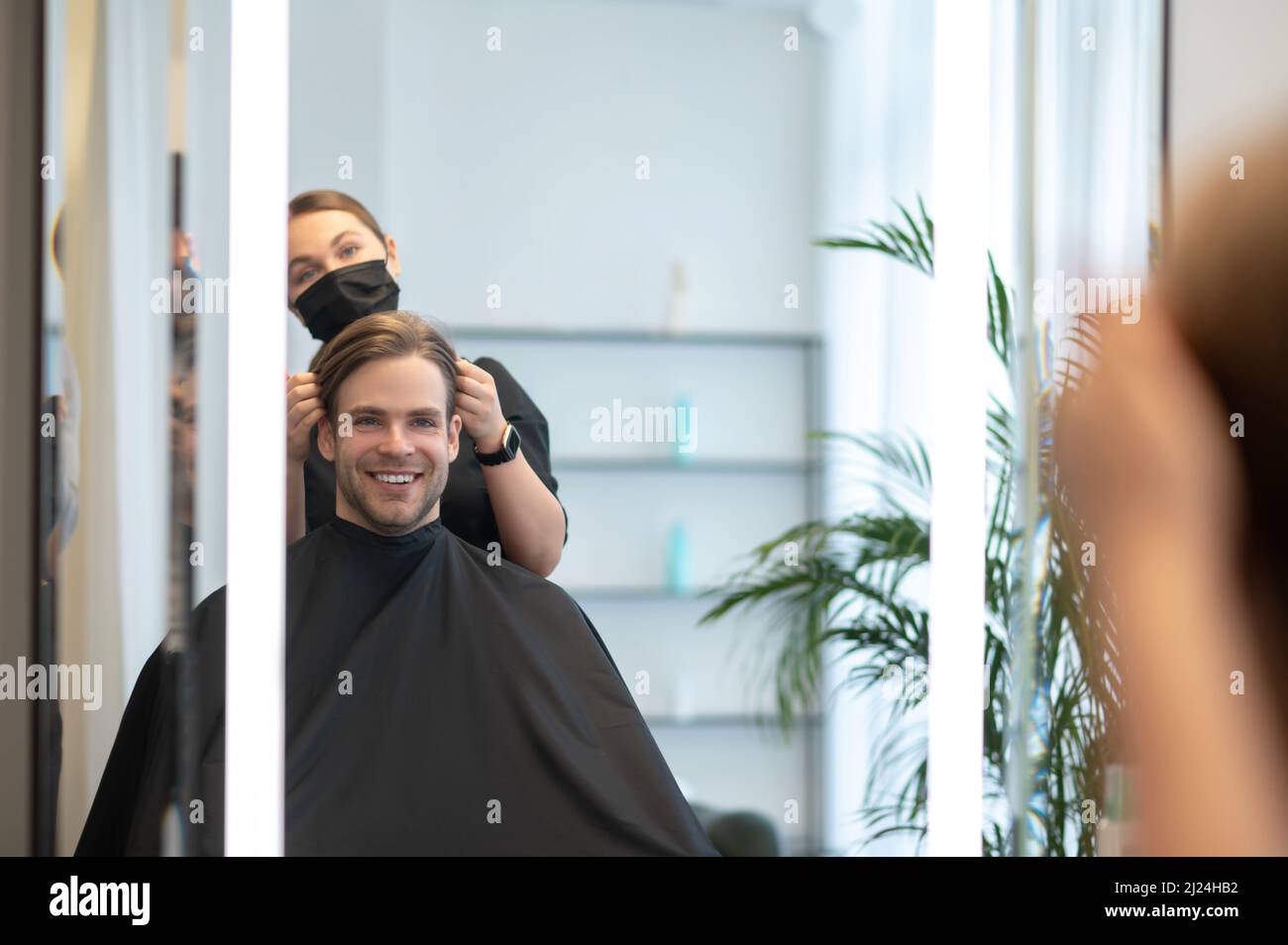 Fair-haired man having hairstyling procedures at the beauty salon Stock ...