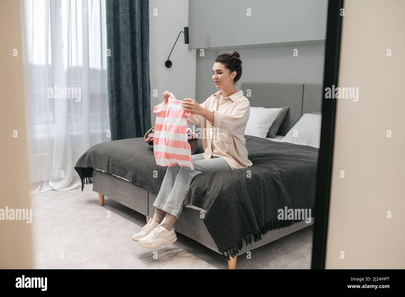 A housewife collecting clothes for washing at home Stock Photo - Alamy