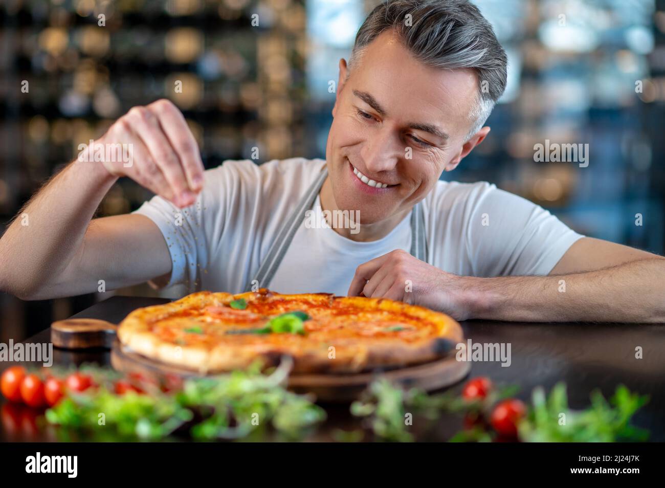 A chef making topping on a italian pizza Stock Photo - Alamy