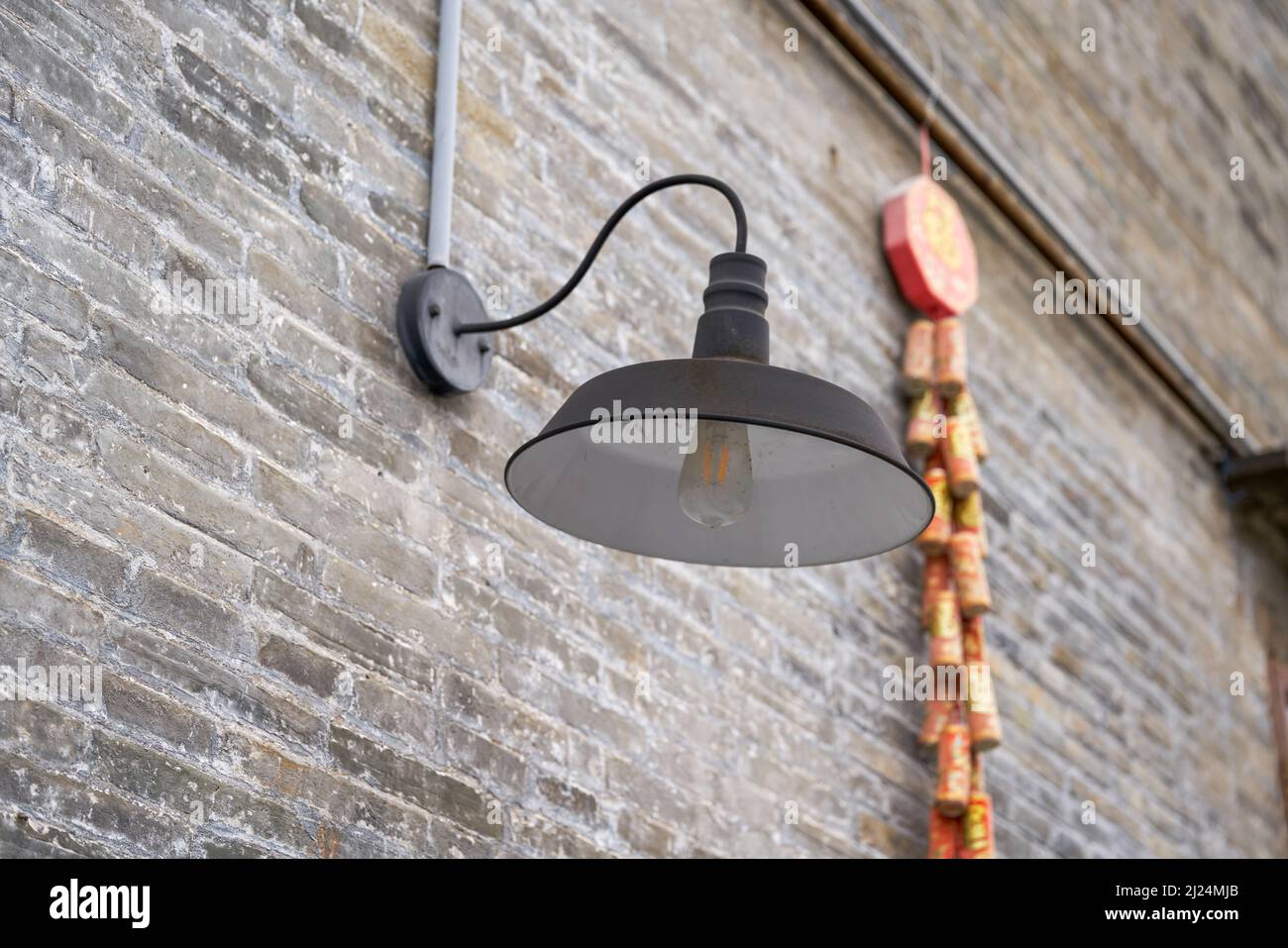 Outdoor street lamp installed on stone wall of ancient Chinese building ...