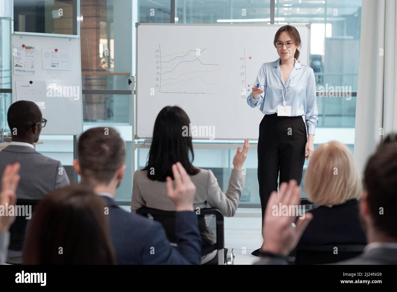 Confident speaker or business coach asking audience questions at ...