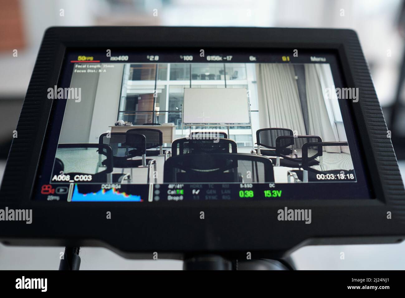 Display of video camera standing behind rows of black chairs and ...