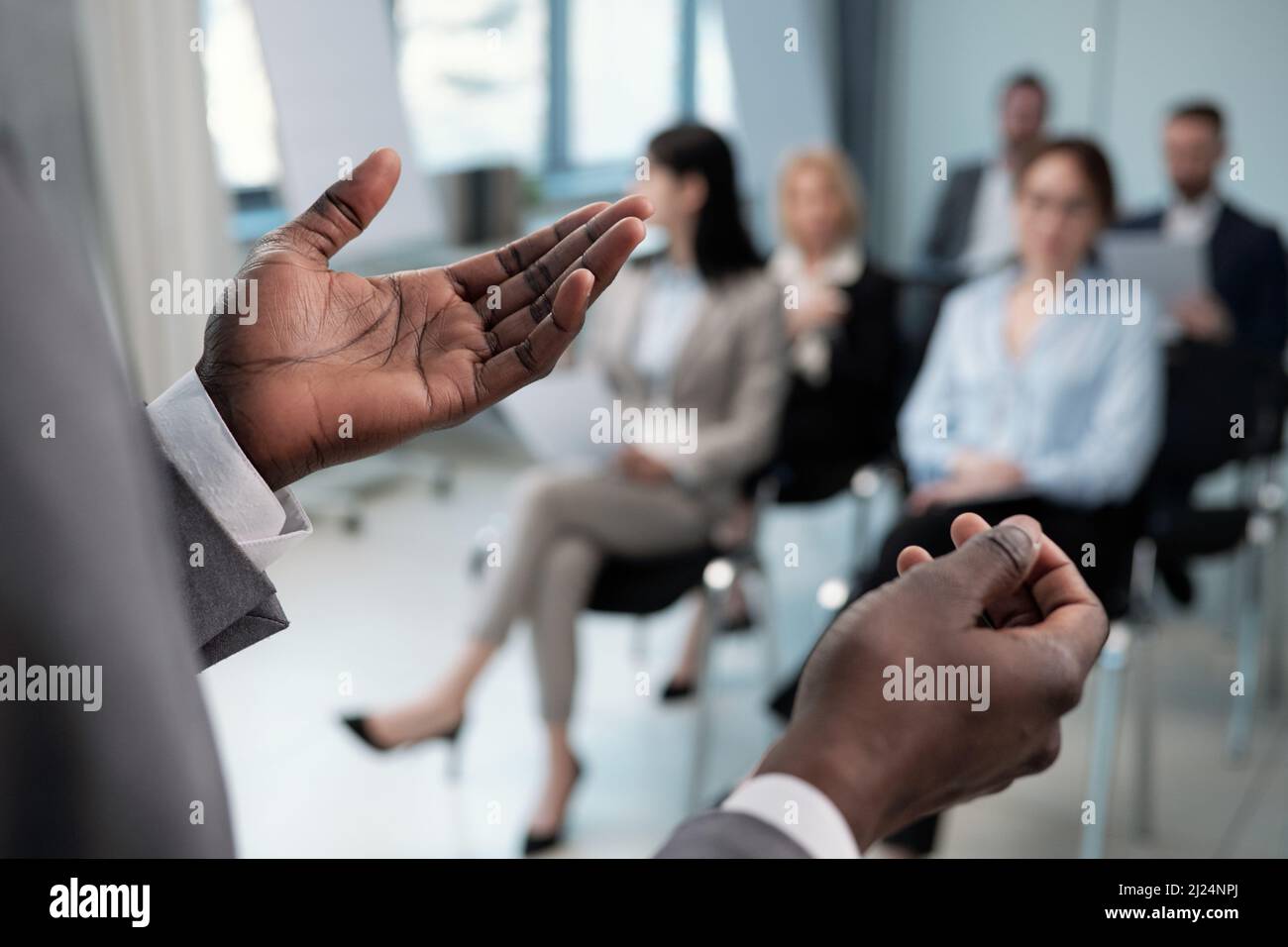 Hands of young African American coach explaining data to audience ...