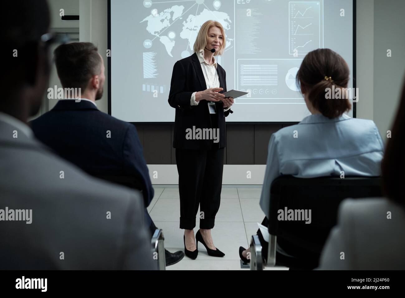 Experienced female business coach speaking in microphpne in front of ...