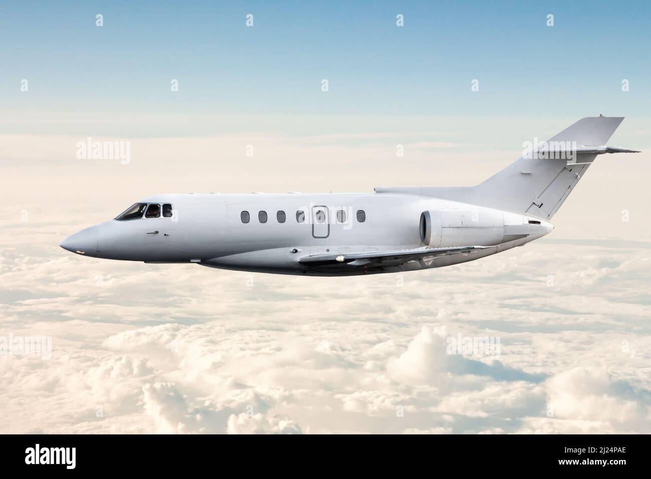 White modern luxury private jet flies in the air above the clouds Stock ...