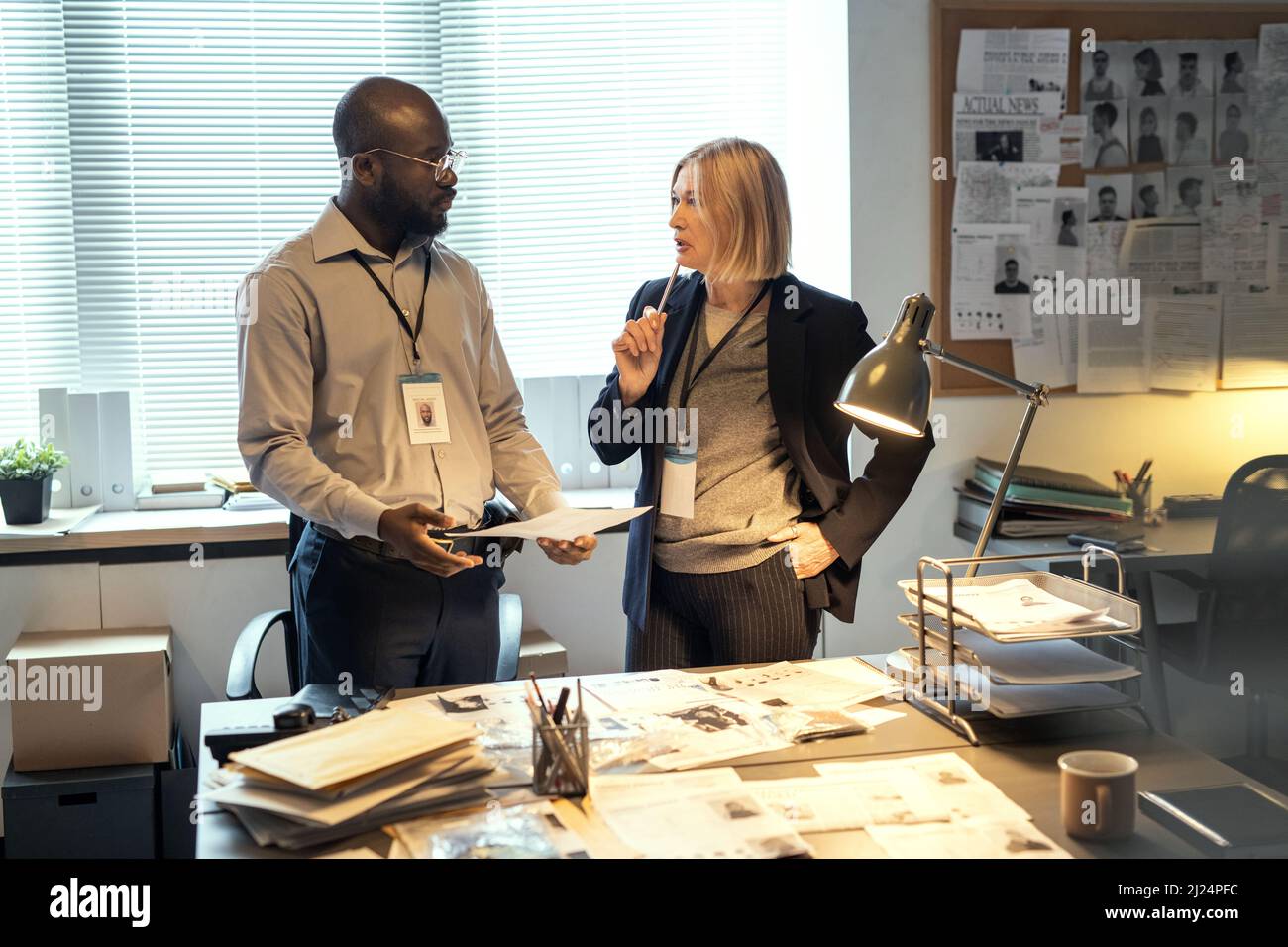 Young serious African American male FBI agent listening to mature ...