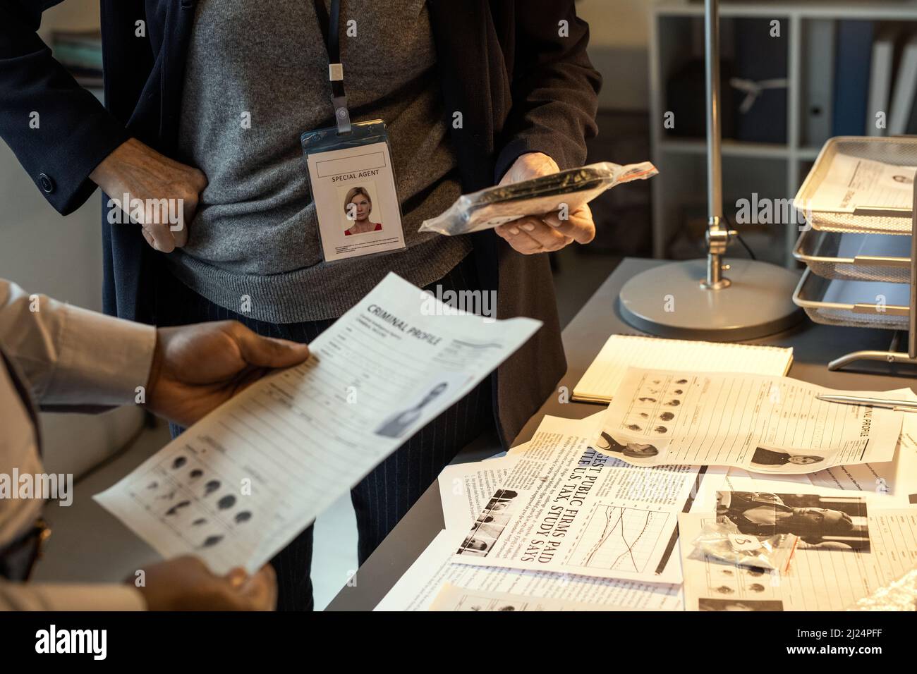 Hands of African American FBI agent looking through one of criminal ...